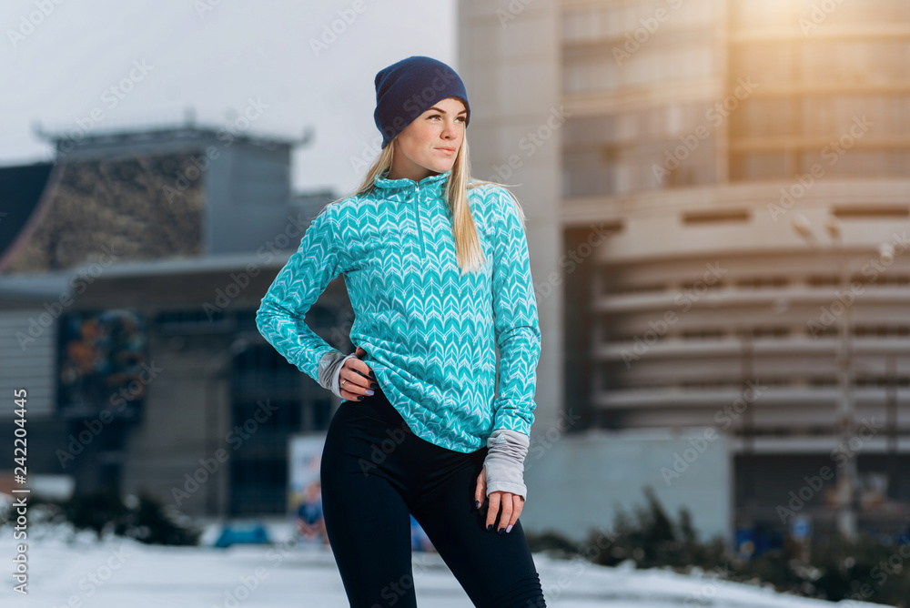 woman in sporty wear in winter training outside in cold snow weather ...