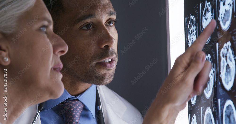 Close view of young black doctor reviewing ct scan of cranium with ...