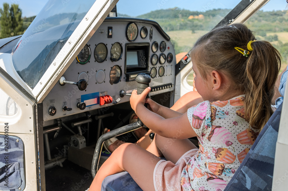 Little adorable girl child - pilot at the steering wheel of a light ...