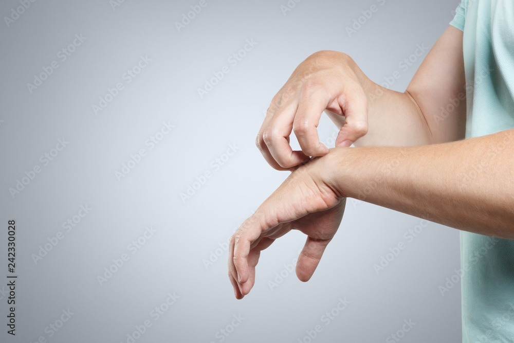 Man scratching himself on grey background Stock Photo | Adobe Stock