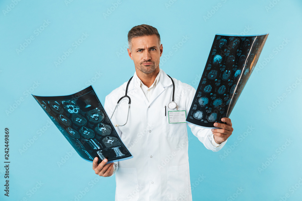 Portrait of neurosurgeon specialist 30s with stethoscope holding x-rays ...
