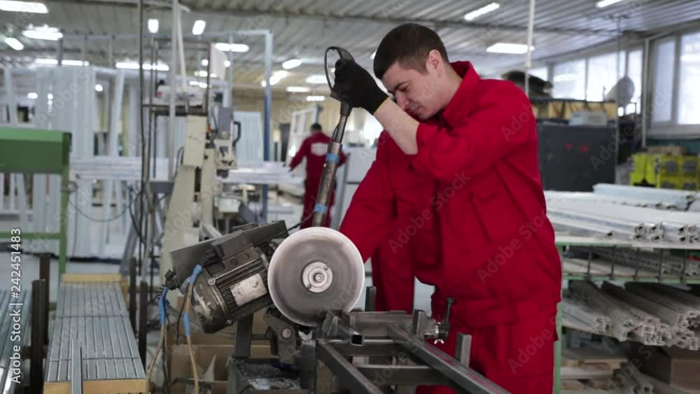 Worker cuts profile for plastic windows. Slicing glazing for plastic ...