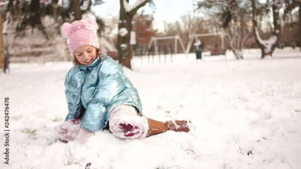 Daughter teenager playing in the snow on the playground with his mature ...