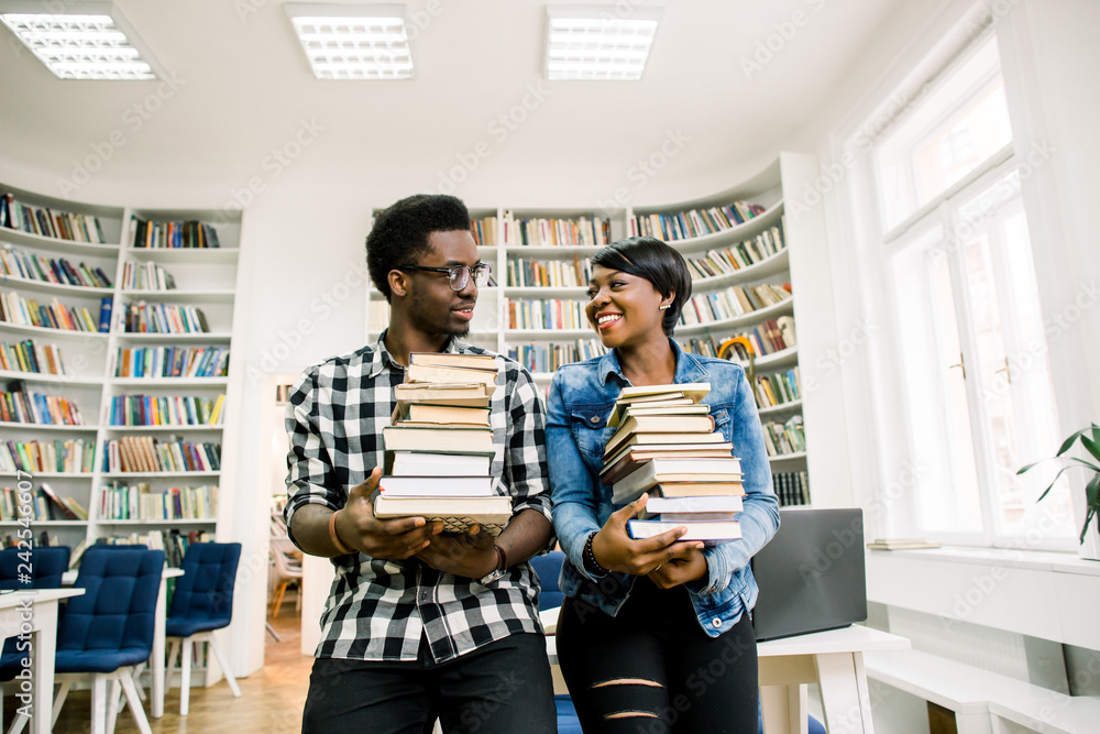 Young smiling african boy and girl holding books standing together on ...
