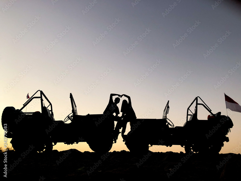 silhouette Romantic couple lovers hug and kiss on a vehicle over a ...