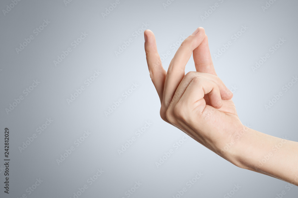 Hand in a snapping gesture on grey background Stock Photo | Adobe Stock