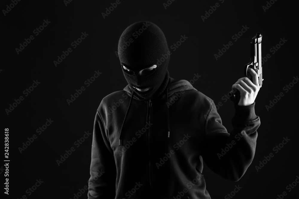 Bandit with gun on dark background Stock Photo | Adobe Stock