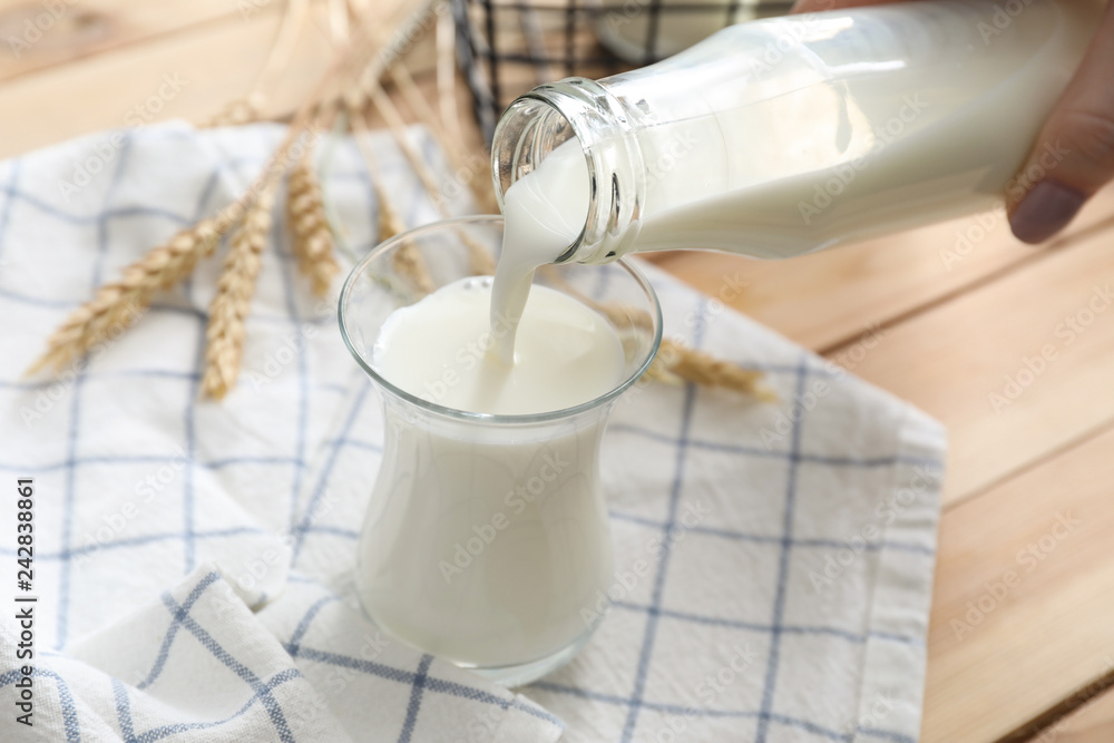 Pouring of fresh milk from bottle into glass on table Stock Photo ...