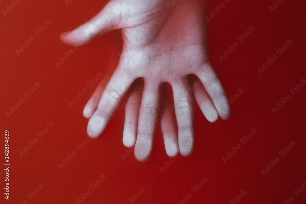 female and male palm with fingers spread to the side drown in red water ...