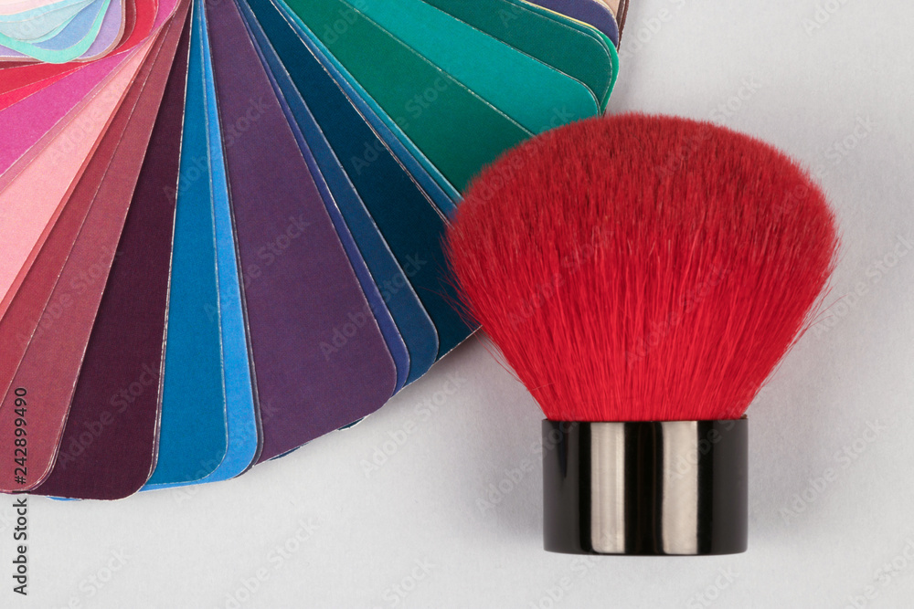 Color fan deck with samples of various paints with red brush for makeup ...