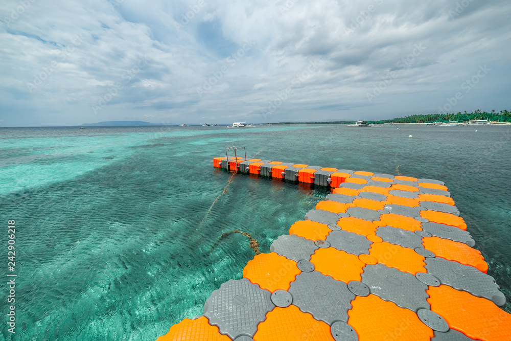 Plastic floating bridge pier on azure sea for tourist on the Dumaluan ...