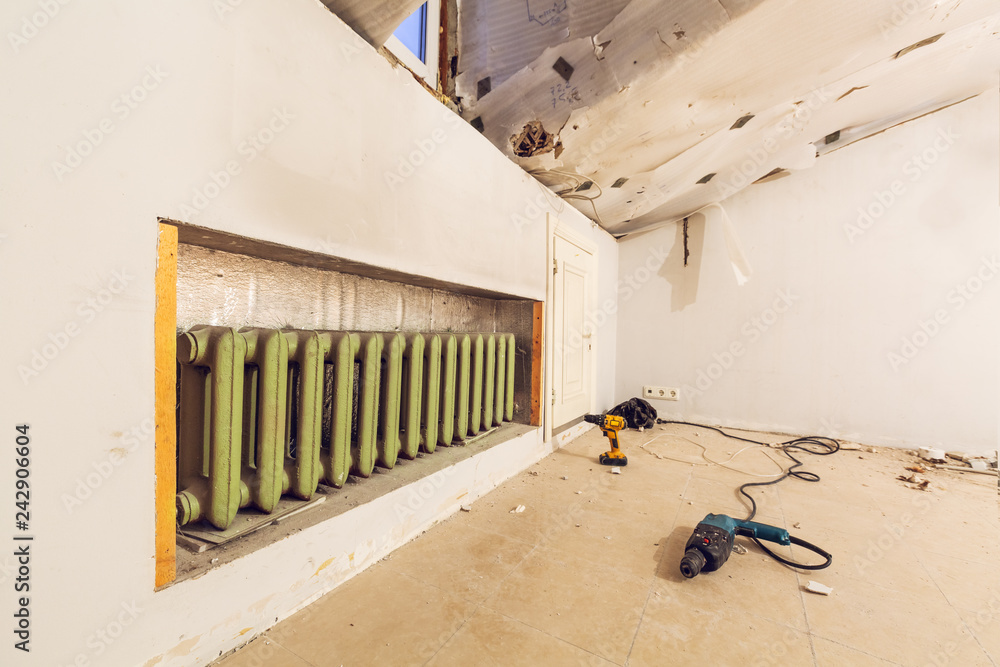 Small room with central heating with heating cast-iron radiator and ...