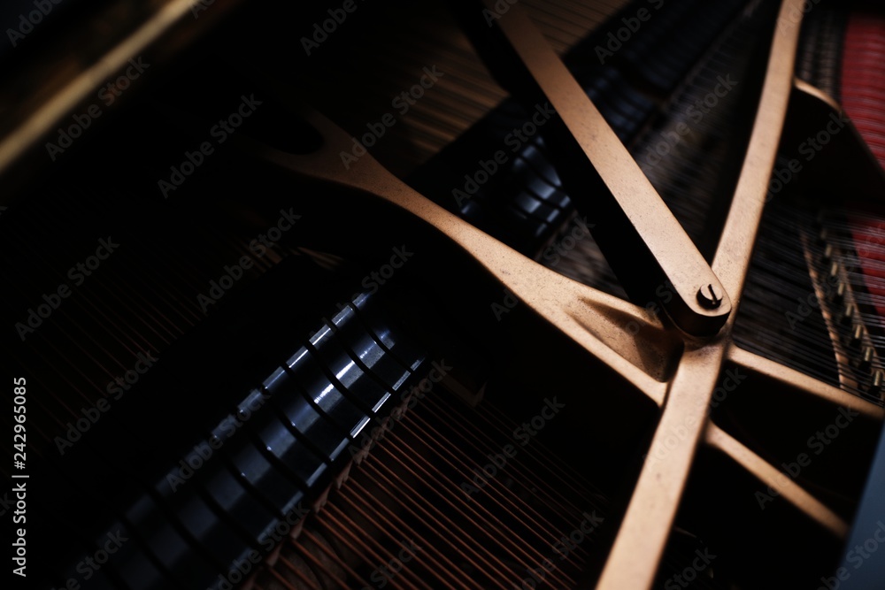 internal parts of an upright piano strings and a tuning key on the pins ...