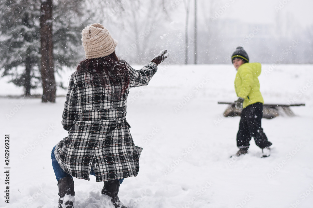 Mom and son playing snowball fight and smiling in winter. Happy family ...