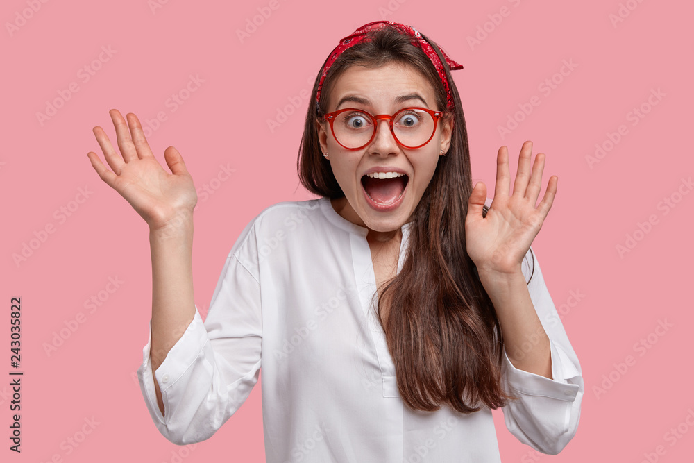 Foto de Headshot of amazed beautiful woman exclaims with happiness ...