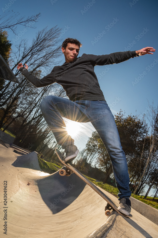 Skateboarder on a tail stall at sunset at the local skatepark. Stock ...