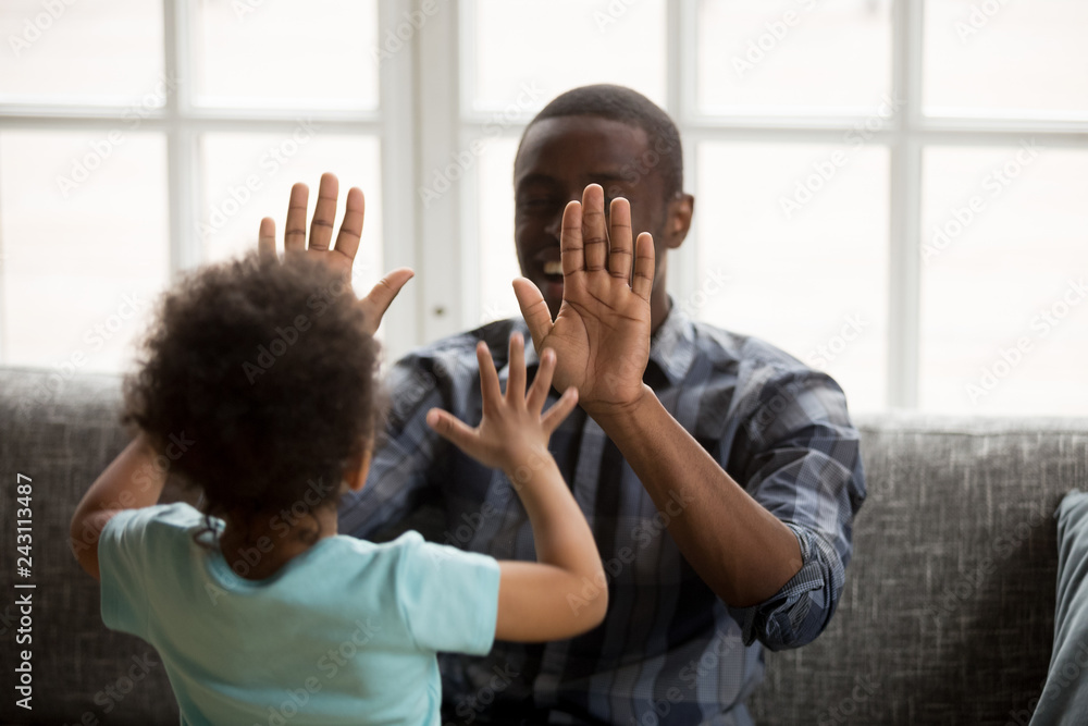 Happy black dad playing patty cake with little son at home, excited ...