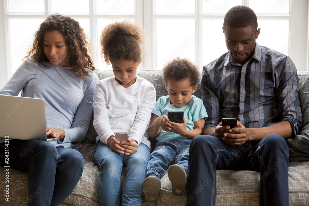 African american family with kids using laptop and mobile phones at ...