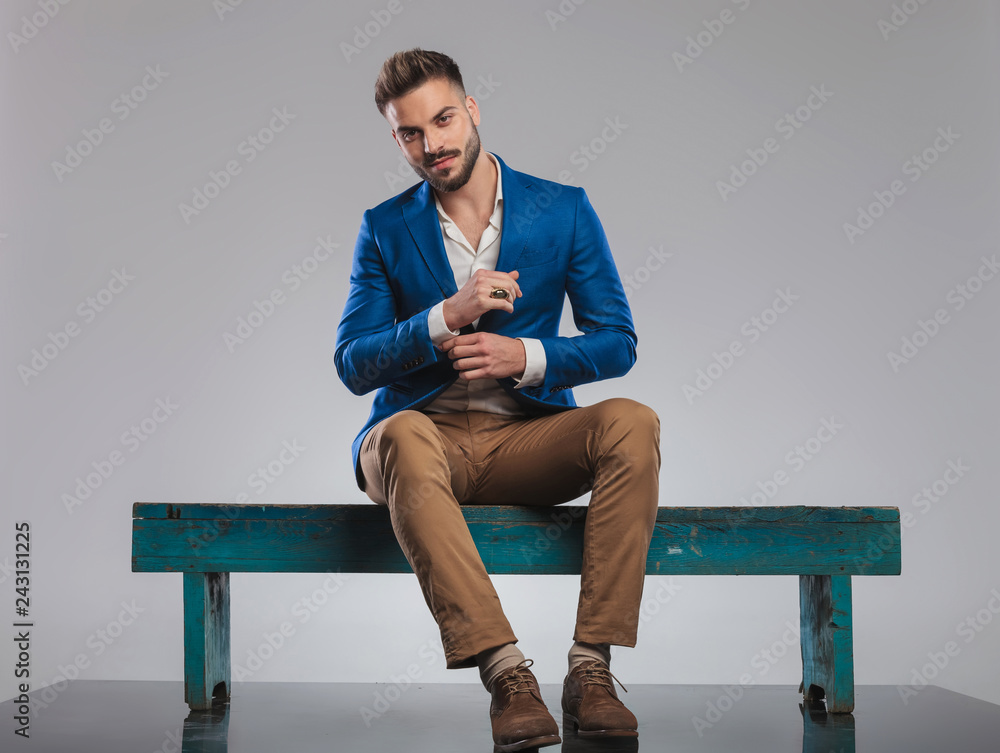 seated smart casual man in blue suit fixes his cuffs Stock Photo ...
