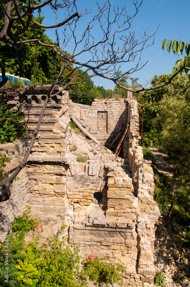 Old ancient destroyed stone house on the yard with trees around ...