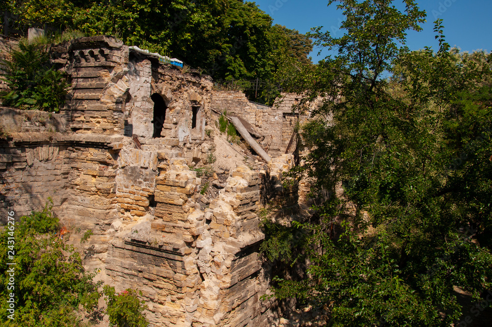 Old ancient destroyed stone house on the yard with trees around ...