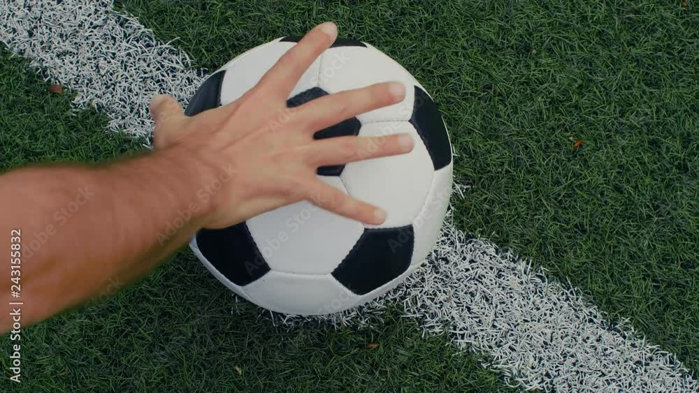 Soccer player puts a ball on the center point of a football field, 4k ...
