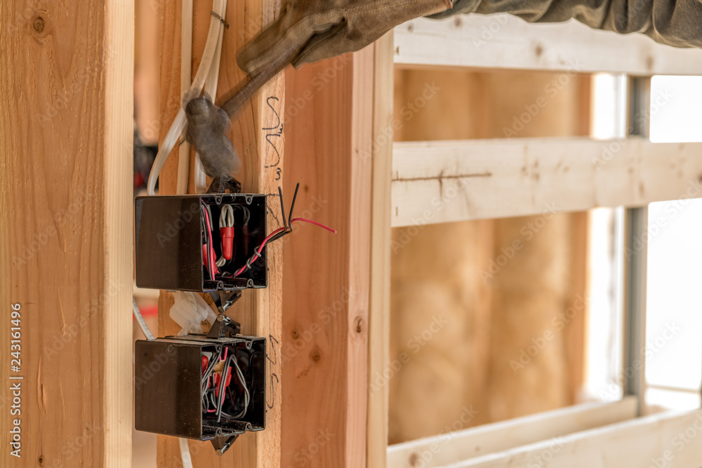 Construction worked hammers an electrical box into the wall studs Stock ...