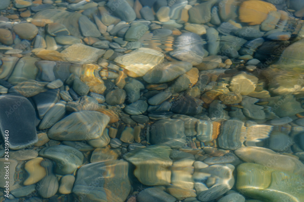Stones in the water. Blue sea water splash. Background of sea water. A ...