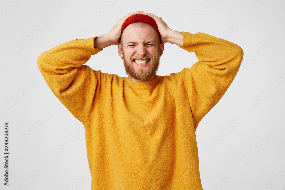 Portrait of young bearded man stands with his eyes closed, holding his ...
