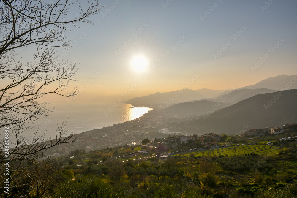 Backlight panoramic view of Borgio Verezzi with the coastal city of ...