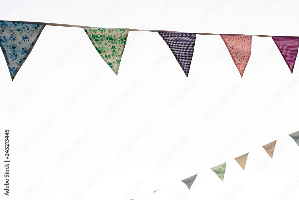 Pennants with blue sky background and pale colors hanging on a rope ...