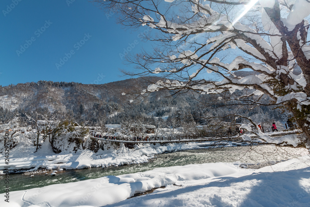 Tourists crossing the Deai-bashi suspension bridge to the village in ...