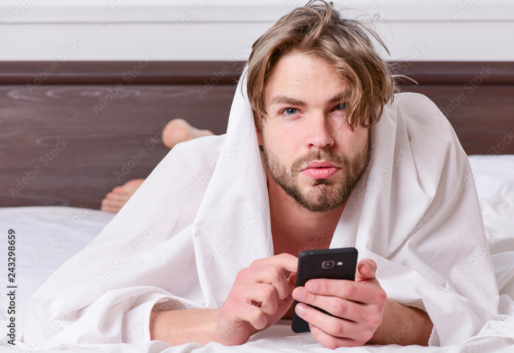 Picture showing young man stretching in bed. Feet of man sleeping in ...