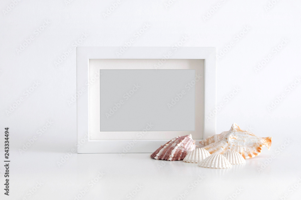 White empty photo frame with light grey color inside and sea shells, on ...