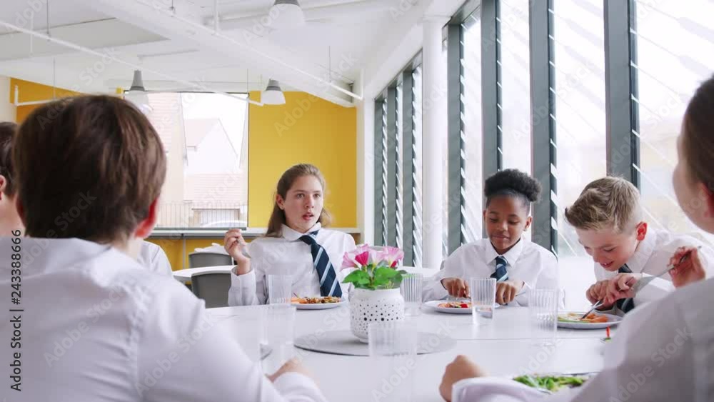 Group Of High School Students Wearing Uniform Sitting Around Table And ...
