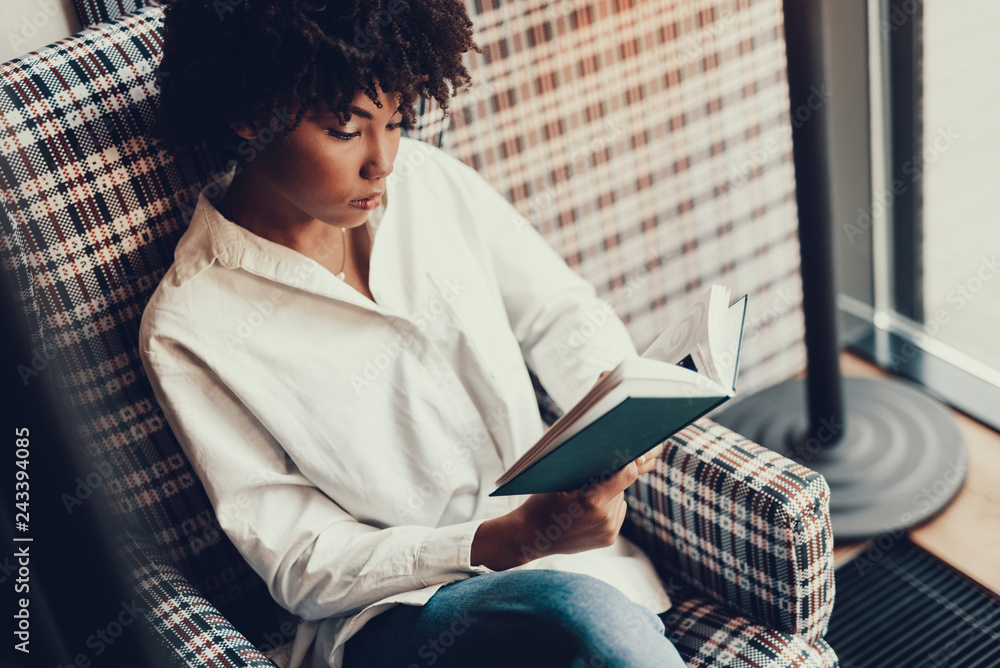Charming woman in white shirt reading book Stock Photo | Adobe Stock