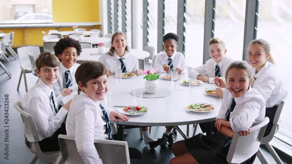 Portrait Of High School Students Wearing Uniform Sitting Around Table ...