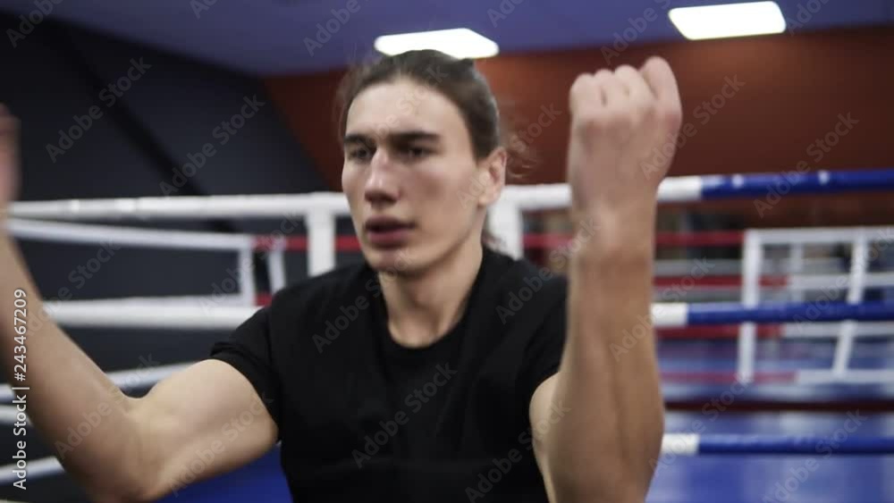 Handhelded footage of a male boxer warming up. Twisting his body,waving ...