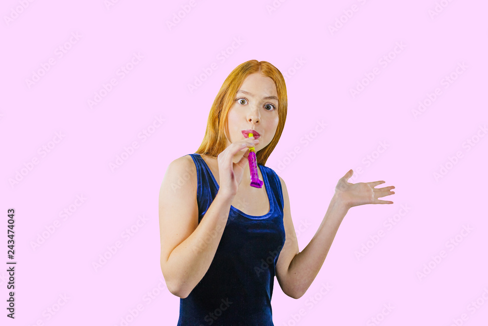 A portrait of a beautiful girl with long red hair holding a festive ...