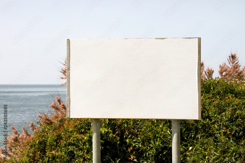 Blank advertising billboard display and table, sea in background ...