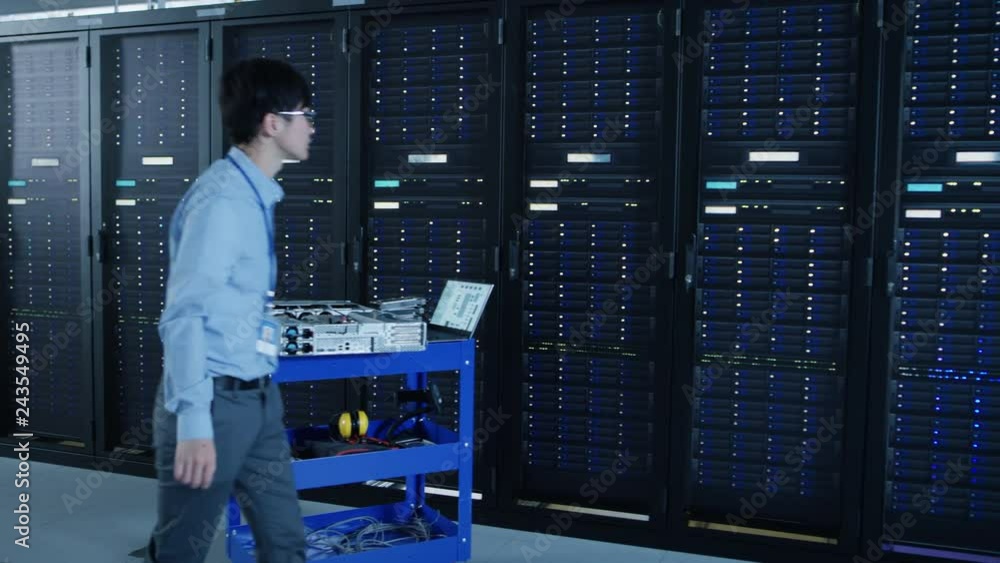 In the Modern Data Center: IT Engineer Doing Maintenance and ...