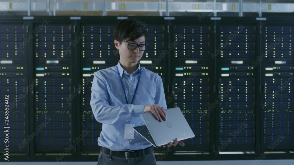 In the Modern Data Center: Portrait of IT Engineer Standing with Server ...
