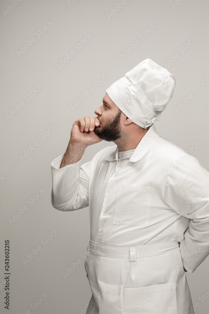 Side view of bearded overweight man in chef uniform rubbing chin and ...