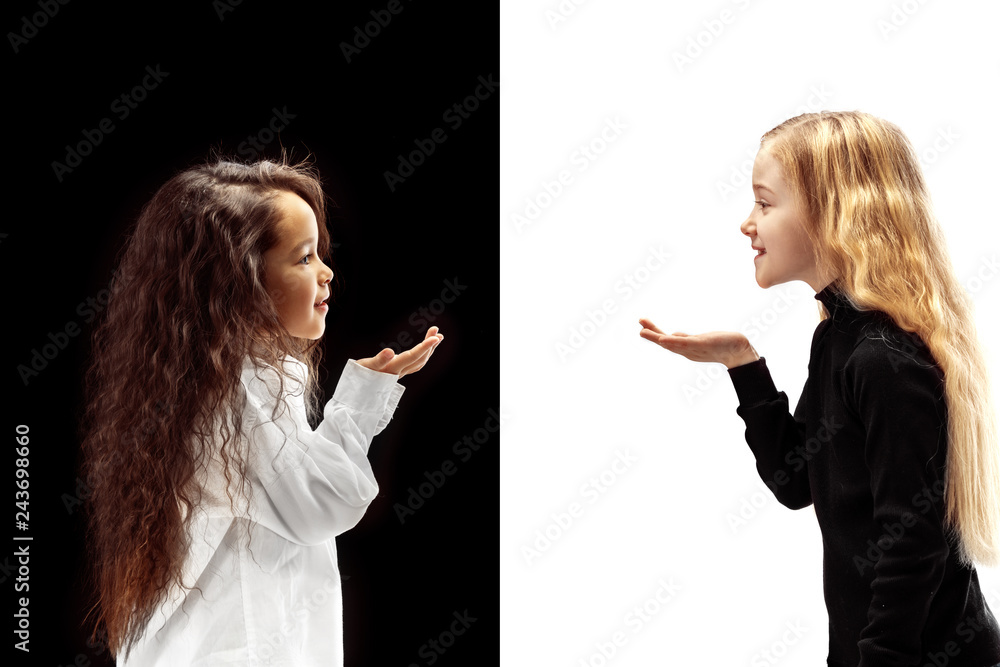 The portrait inf profile of two happy girls on a white and black studio ...
