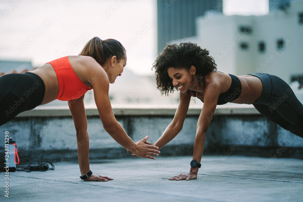 Fitness women doing push ups together on rooftop Stock Photo | Adobe Stock