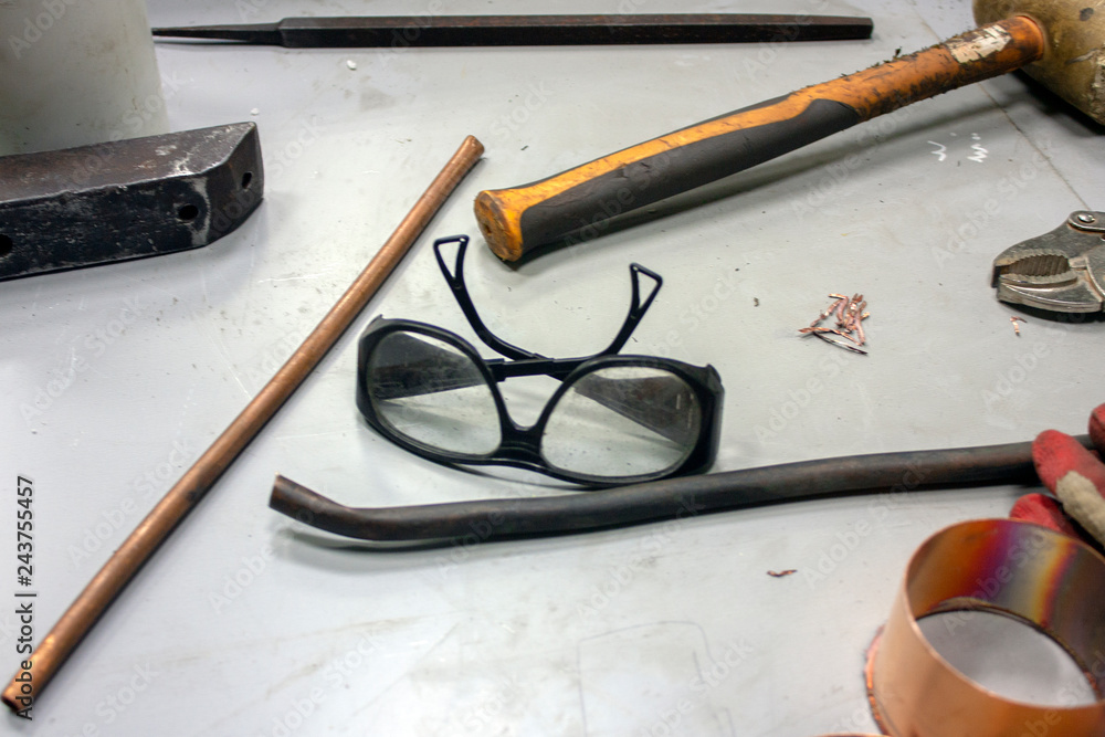 Hand tools, parts of products and blanks on the desktop of the workshop ...