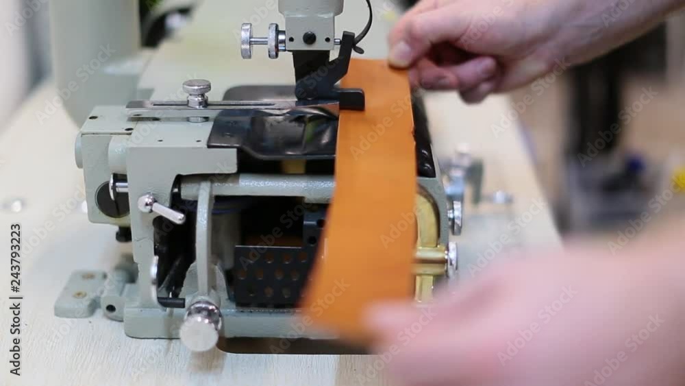Operator is adjusting automatic leather skiving machine in a ...