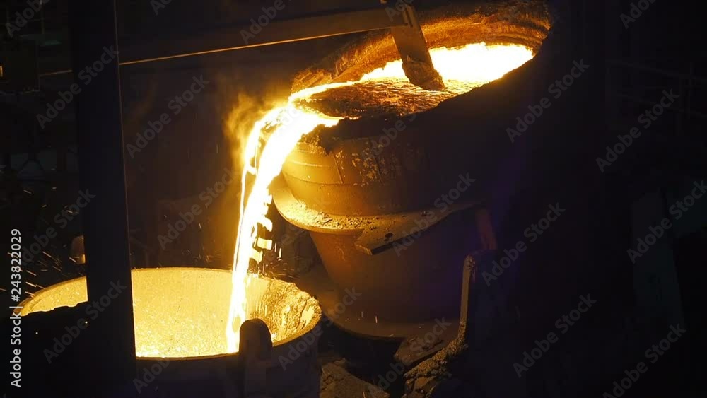 Iron and steel works. Molten metal pouring out of furnace. Liquid metal ...