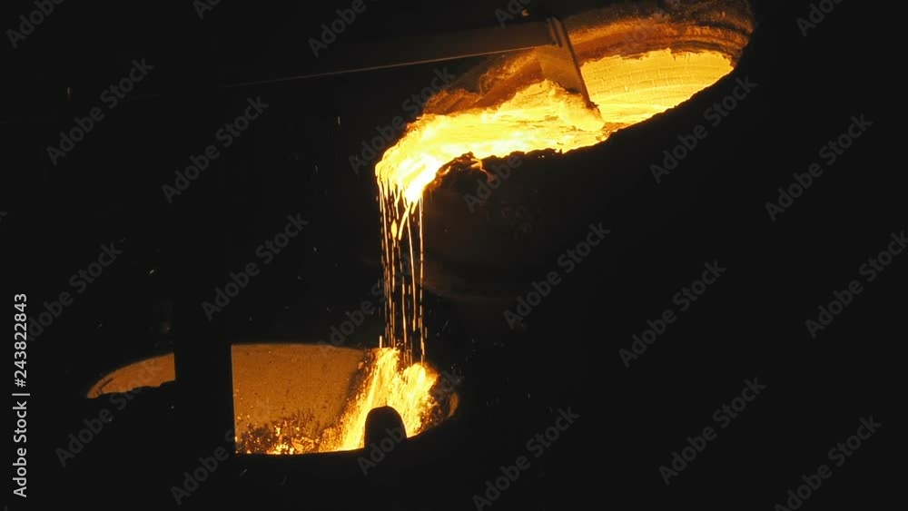 Iron and steel works. Molten metal pouring out of furnace. Liquid metal ...