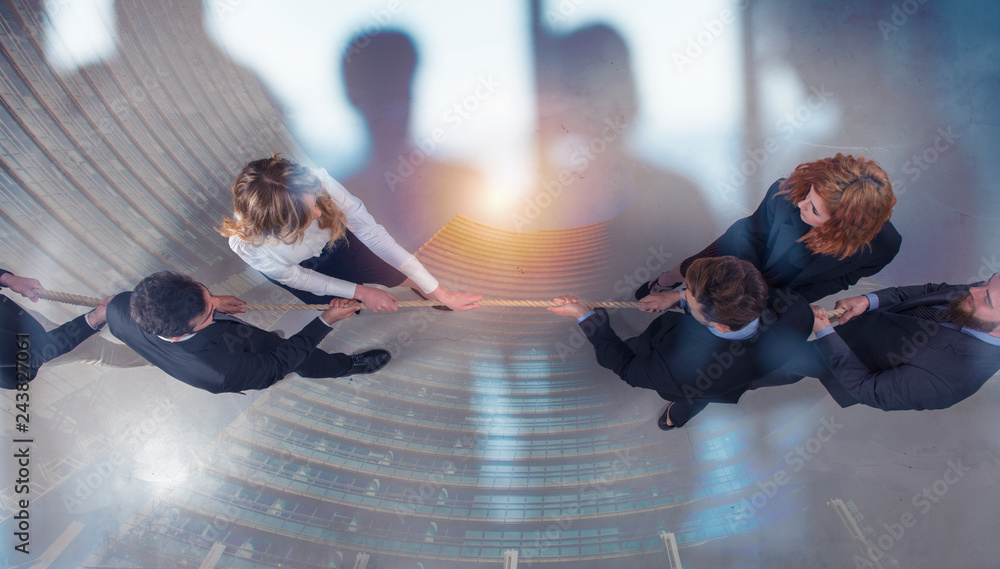 Rival business man and woman compete for the command by pulling the ...